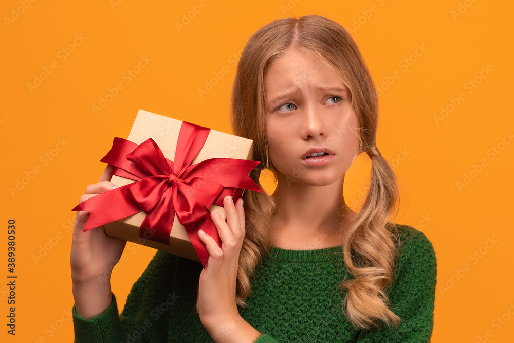 Image of charming blonde girl 12-14 years old holding present box with ...