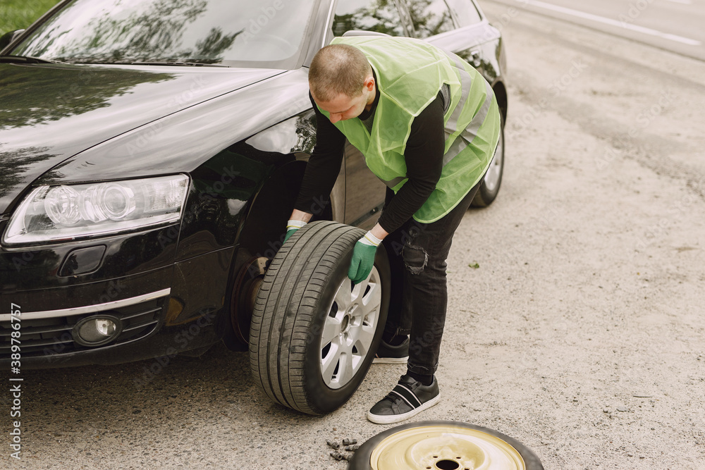 Worker changes a broken wheel of a car. The driver should replace the ...