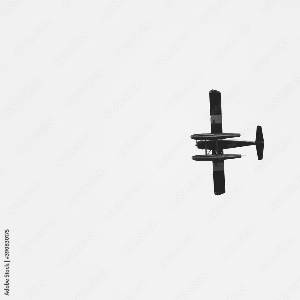 Single engine bush plane flying across open sky (plane is a DeHavilland ...