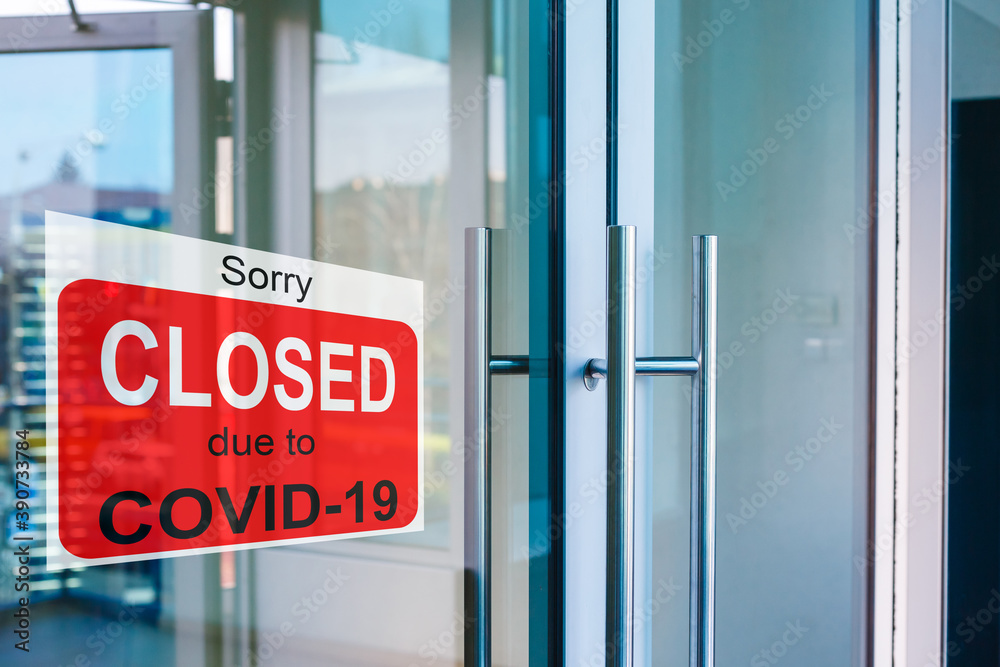 Business center closed due to COVID-19, sign with sorry in door window ...