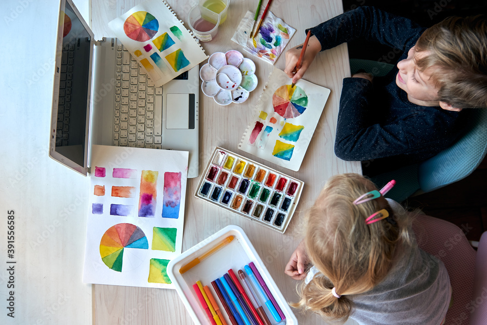 Children painting pictures with watercolor paints during art lesson ...