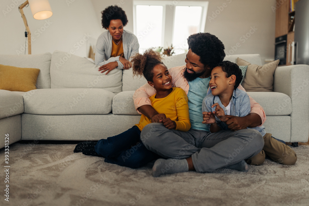 Afro parents and their children are socializing while sitting on the ...