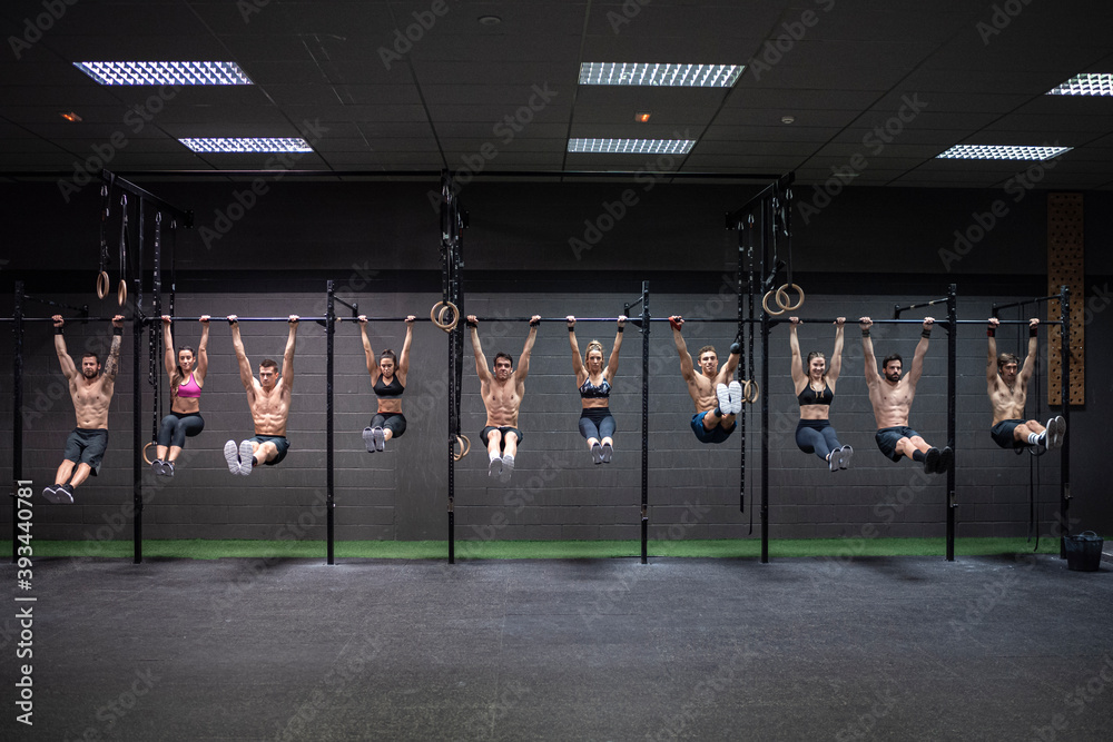 Male and female athletes hanging on rod at gym Stock Photo | Adobe Stock