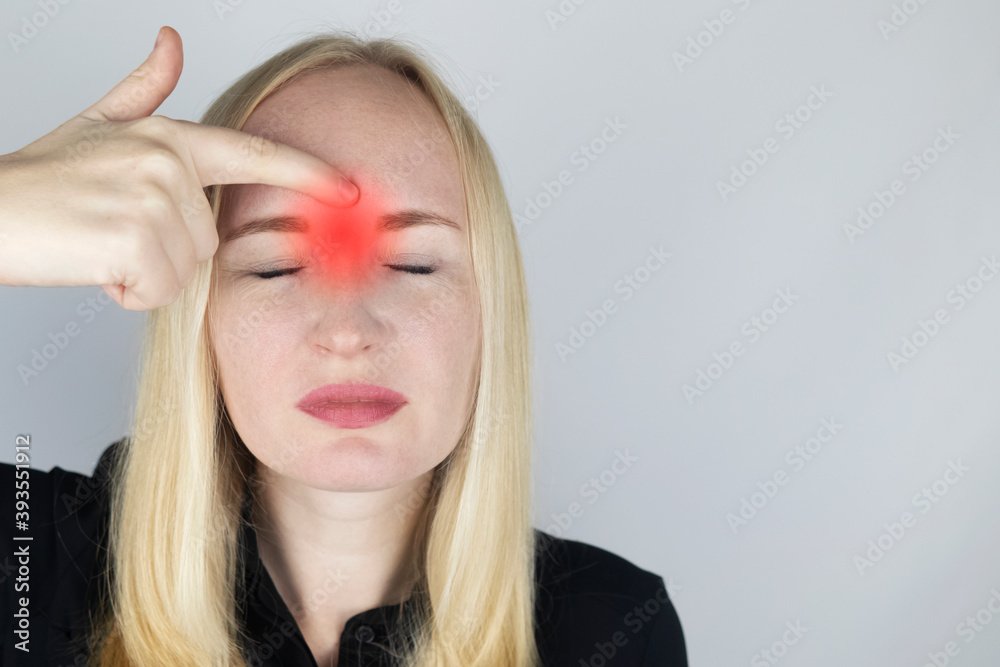 Nasal bridge pain, headache. A woman holds his nose with his hand and ...