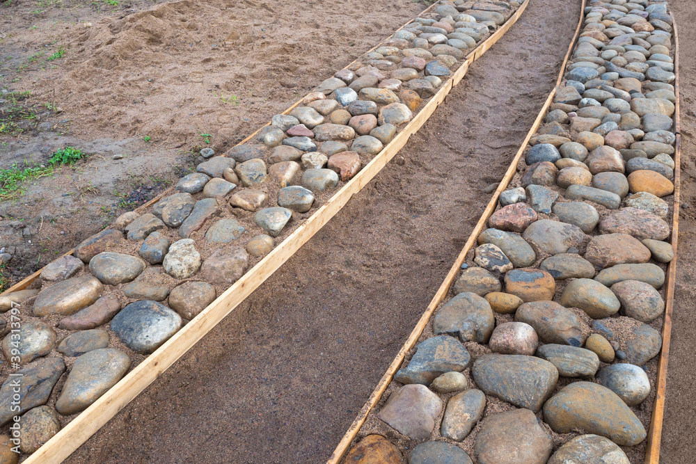 Foto Two parallel cobblestone paths. Pavement construction using stone ...