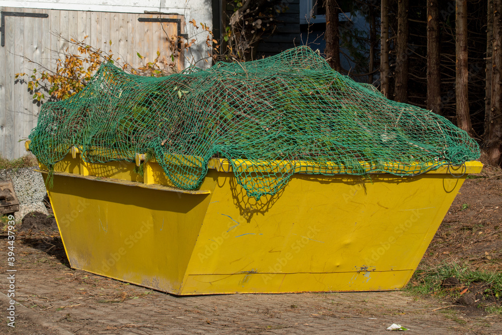 Photo Stock Eine gelbe Mulde, Container wird mit Bauschutt und Holz ...