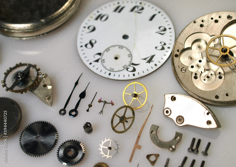 display of parts of vintage watch mechanism: dial, gears, screws ...