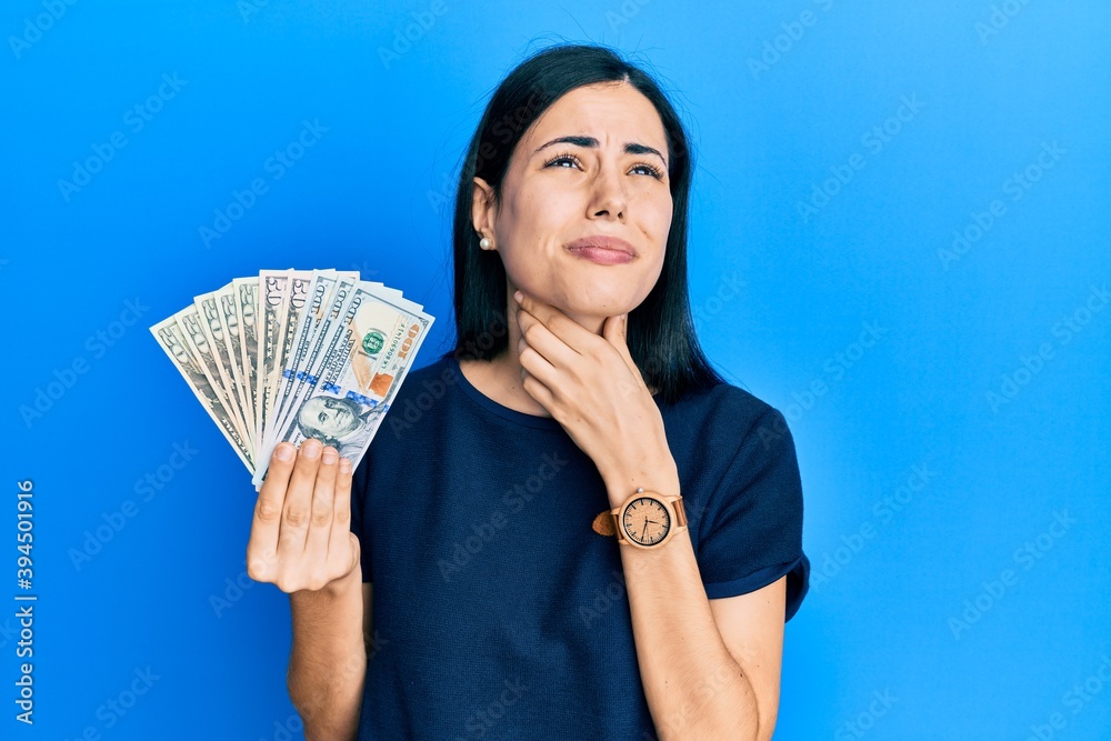Beautiful young woman holding dollars touching painful neck, sore ...
