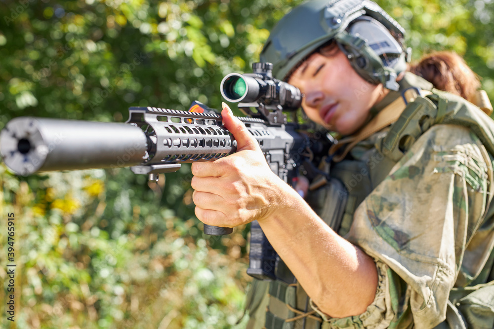 sportive caucasian woman soldier shooting with rifle machine gun in the ...