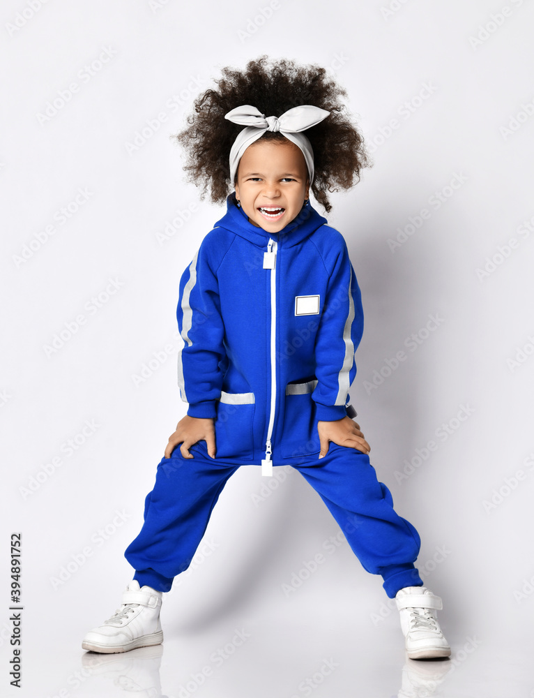 Portrait of frolic active dark-skinned kid girl wearing warm blue ...