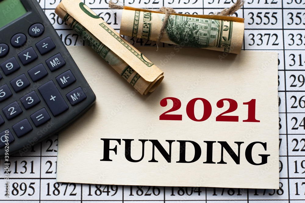 2021 FUNDING - words on white paper against the background of a table ...