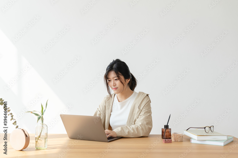 Happy Asian woman at home using a a laptop Stock Photo | Adobe Stock