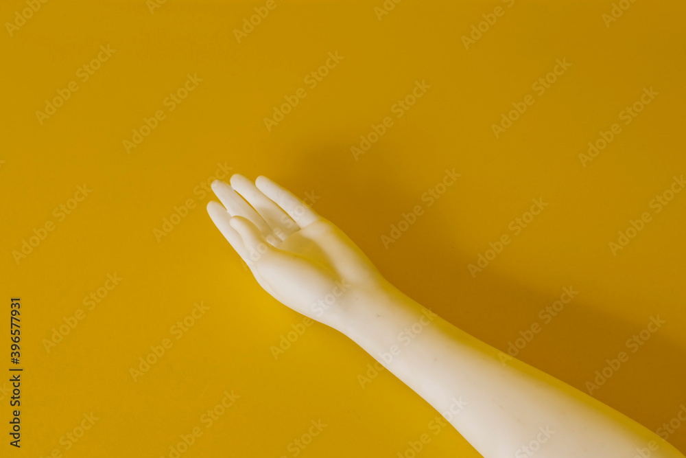 arm of a white dummy model at yellow background. Yellow minimal ...