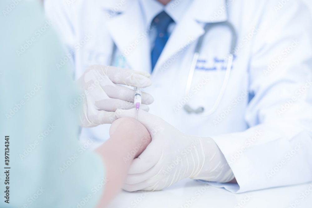 The doctor gives anti-inflammatory injections to the patient's hands to ...