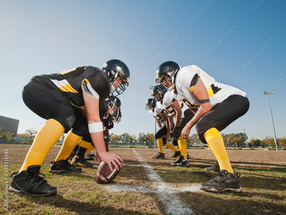 Football players crouching on football field Stock Photo | Adobe Stock