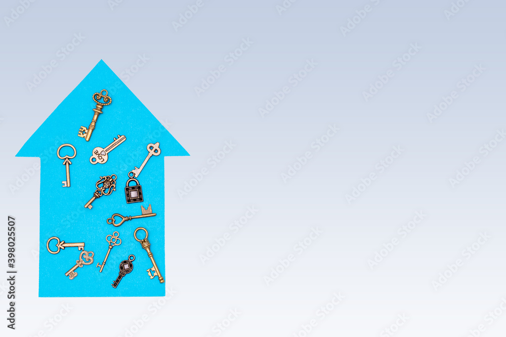 Dream home concept. Model of a blue paper house and keys on a pastel ...