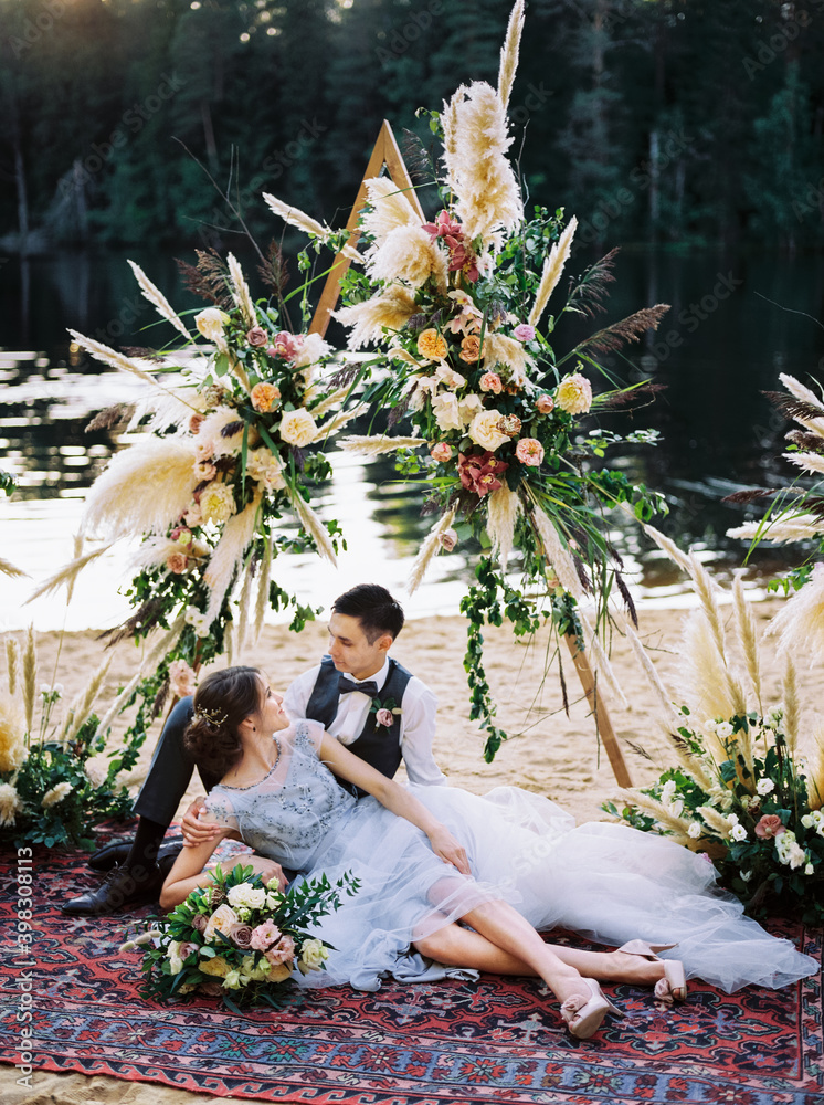 Bride and groom sitting near arch for wedding ceremony Stock Photo ...