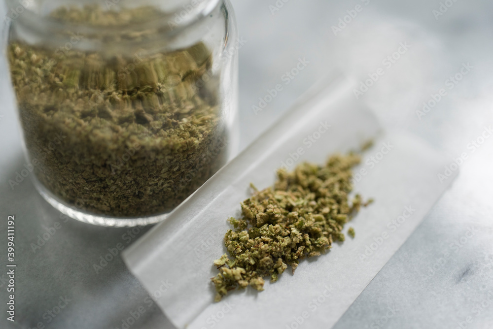 Marijuana in rolling paper and glass jar Stock Photo | Adobe Stock