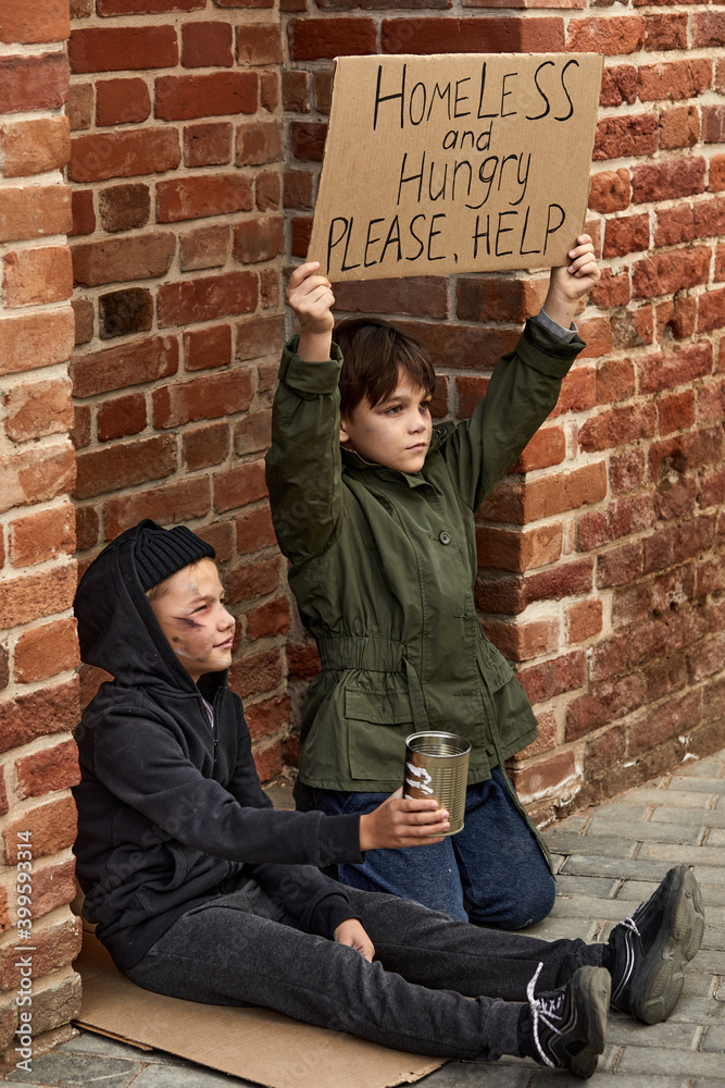 poor little children begging in the buzy street in big city, boys look ...