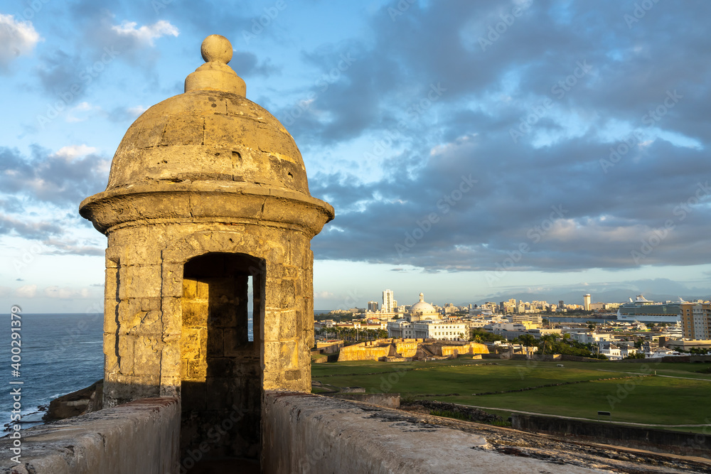 Turret at Castillo San Cristobal Fort with city in background at sunset ...