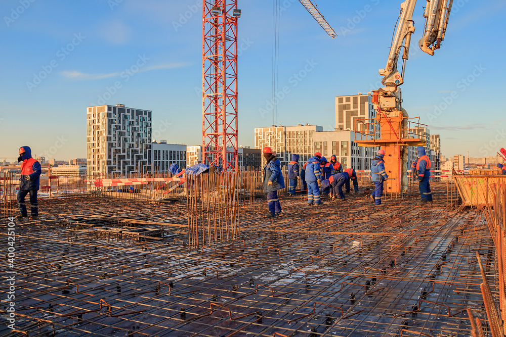 Bar bender fixing steel reinforcement for house concrete floor slab. construction worker ...