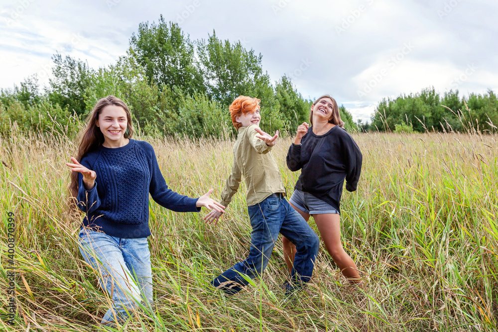 Summer holidays vacation happy people concept. Group of three friends boy and two girls dancing ...