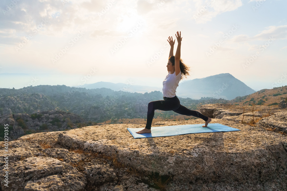 Full body of barefoot female standing in warrior pose on top of ...
