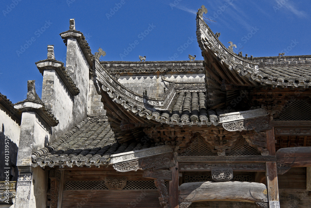 Peaked tile roof and carved wood facade of ancestral hall in ancient ...