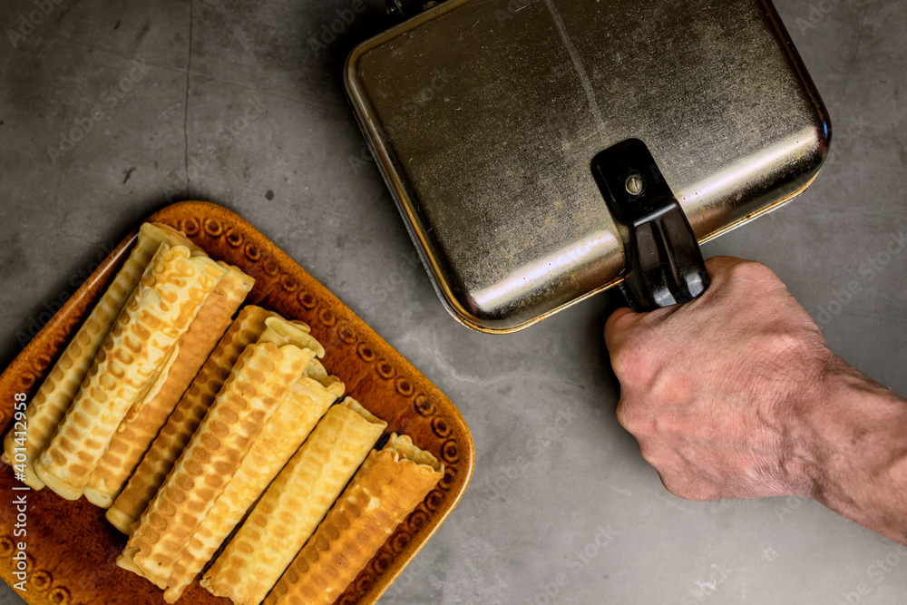 Cooking waffles at home - a waffle iron, a man's hand holding a pen ...
