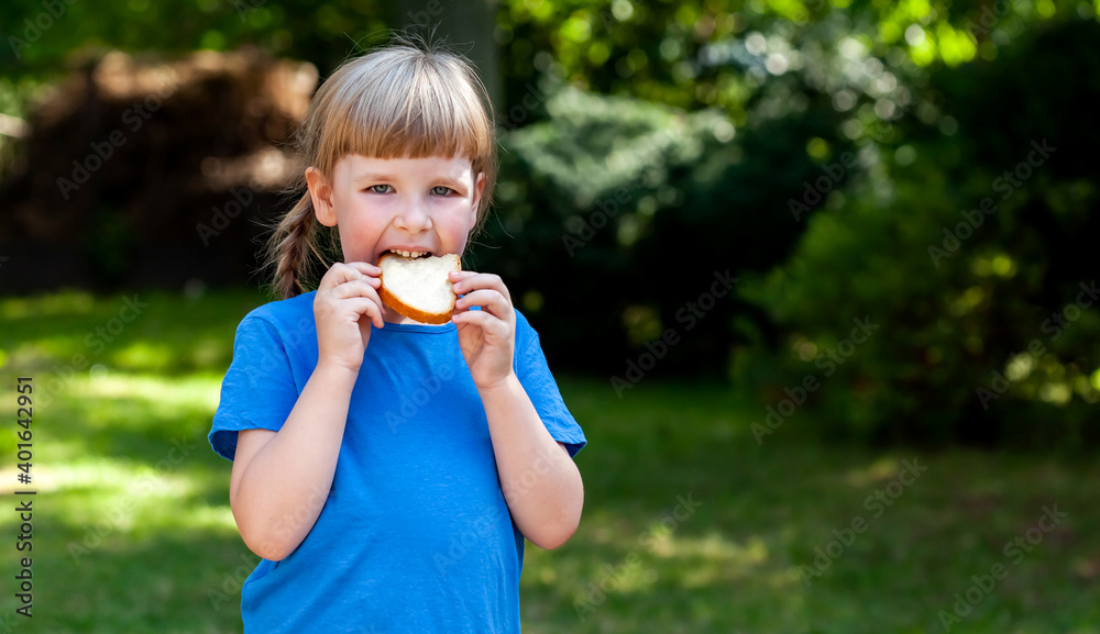 Child, one little girl eating a plain slice of bread with butter in the ...