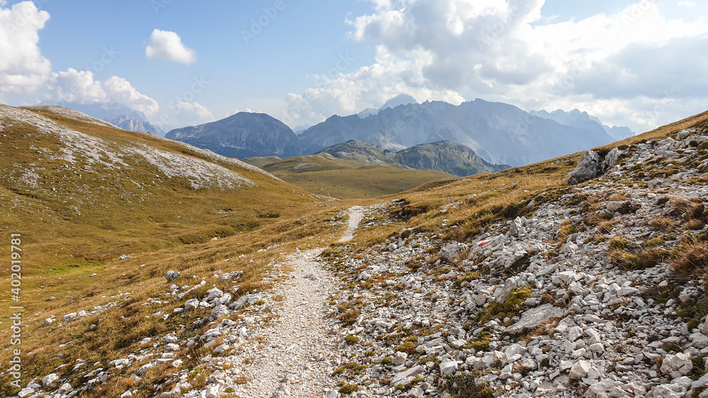 A narrow pathway along a high plateau in Italian Dolomites. There are ...