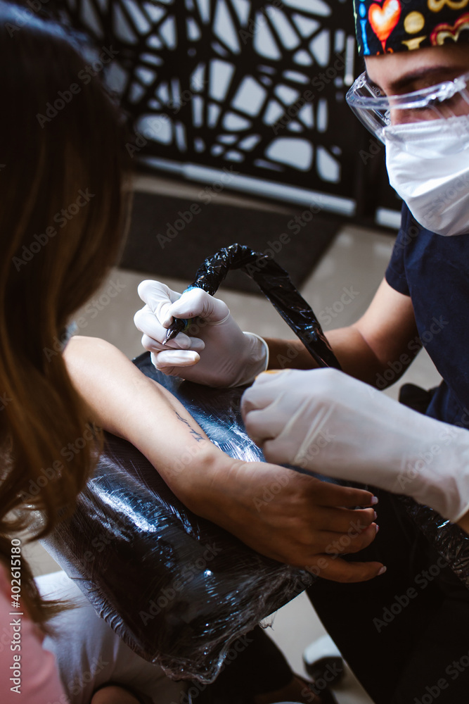 latin woman tattoo master showing a process of creation tattoo in ...