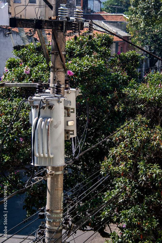 Electric power transformer on a public lighting pole on street in ...
