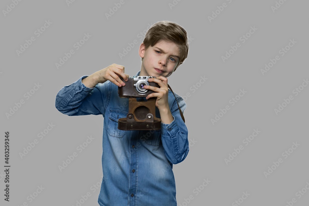 Little boy using film camera on gray background. Cute kid with an old ...