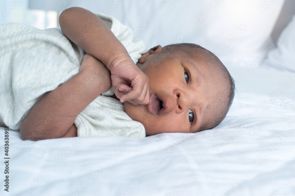 Dark skinned new born baby boy relax in a white bedroom, 15 days year ...