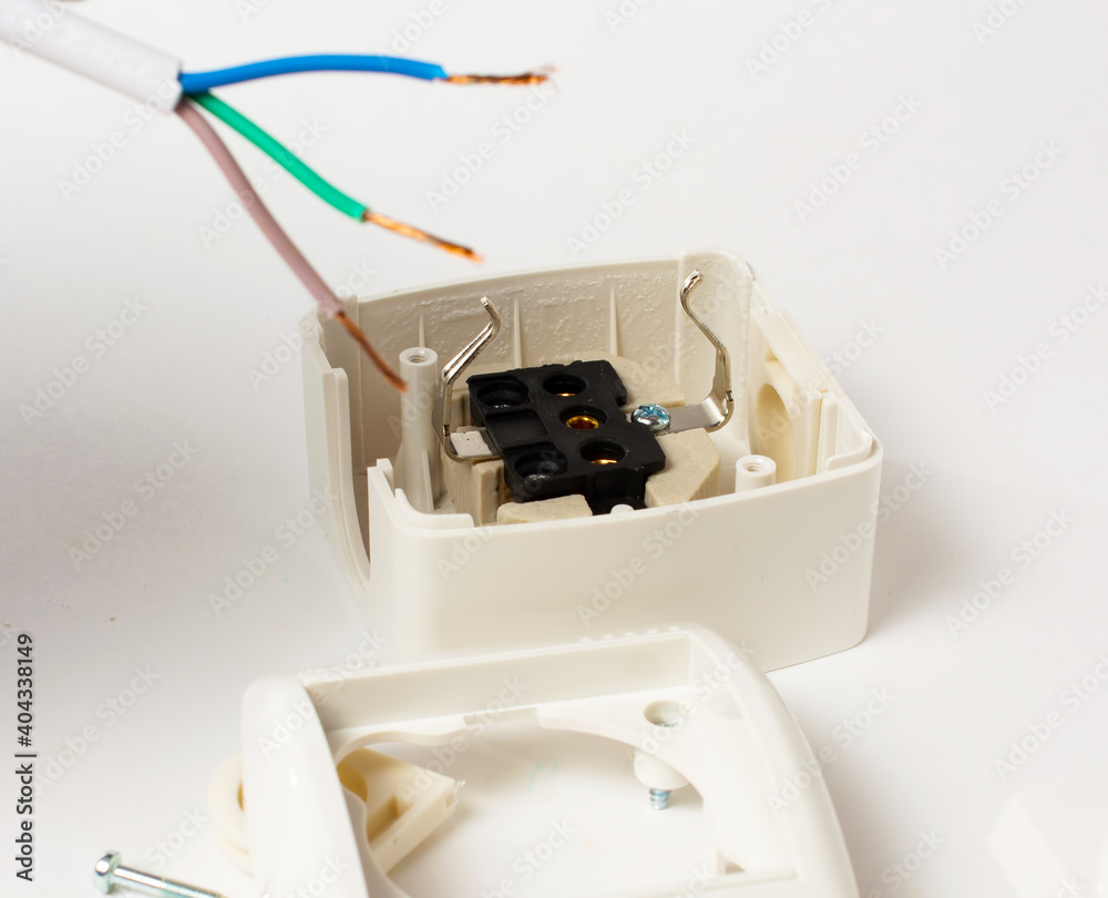on a white table, a disassembled electrical outlet ready to install ...