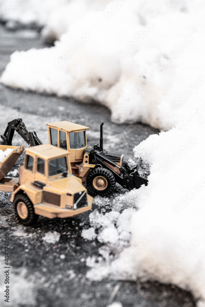Focus on digger.Model digger and cargo trucks collecting snow of the ...