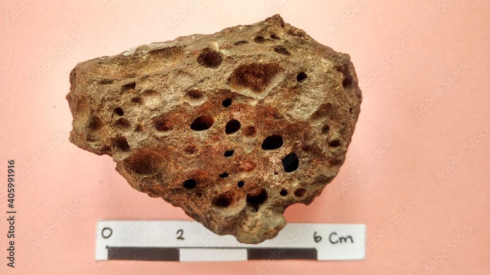 Extrusive volcanic igneous rock, vesicular basalt. Dark brown and ...