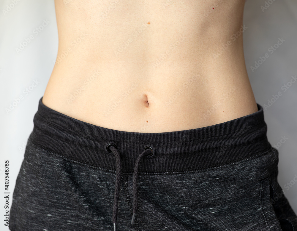 Flat female belly. Woman showing her flat belly. Body parts: athletic ...