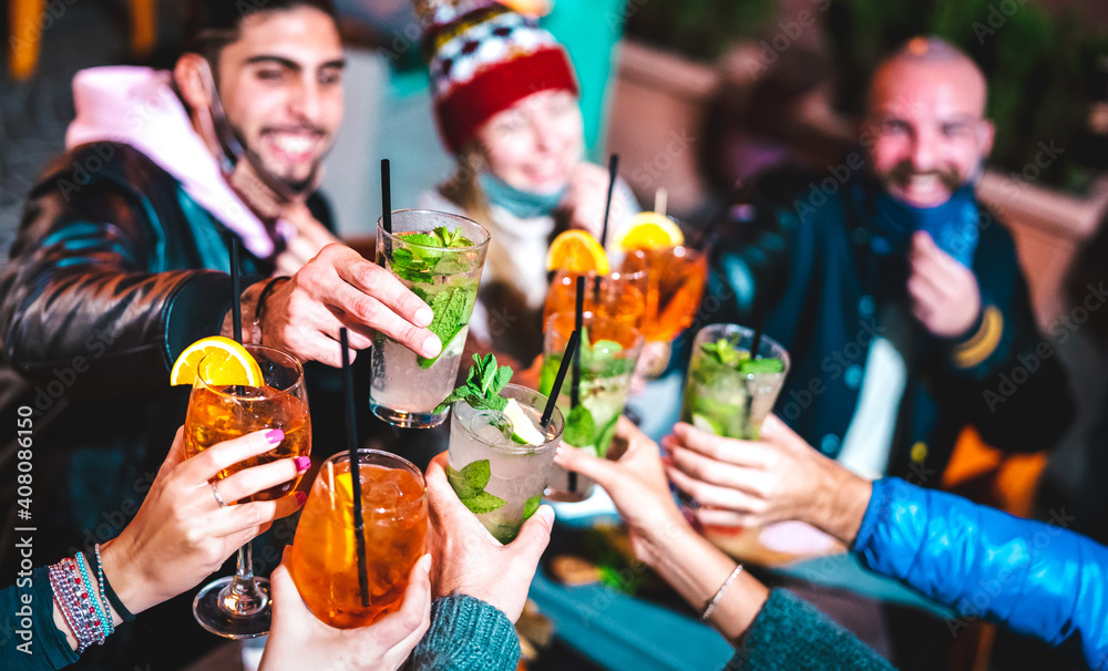 Foto Happy friends toasting drinks at night bar with open face mask ...