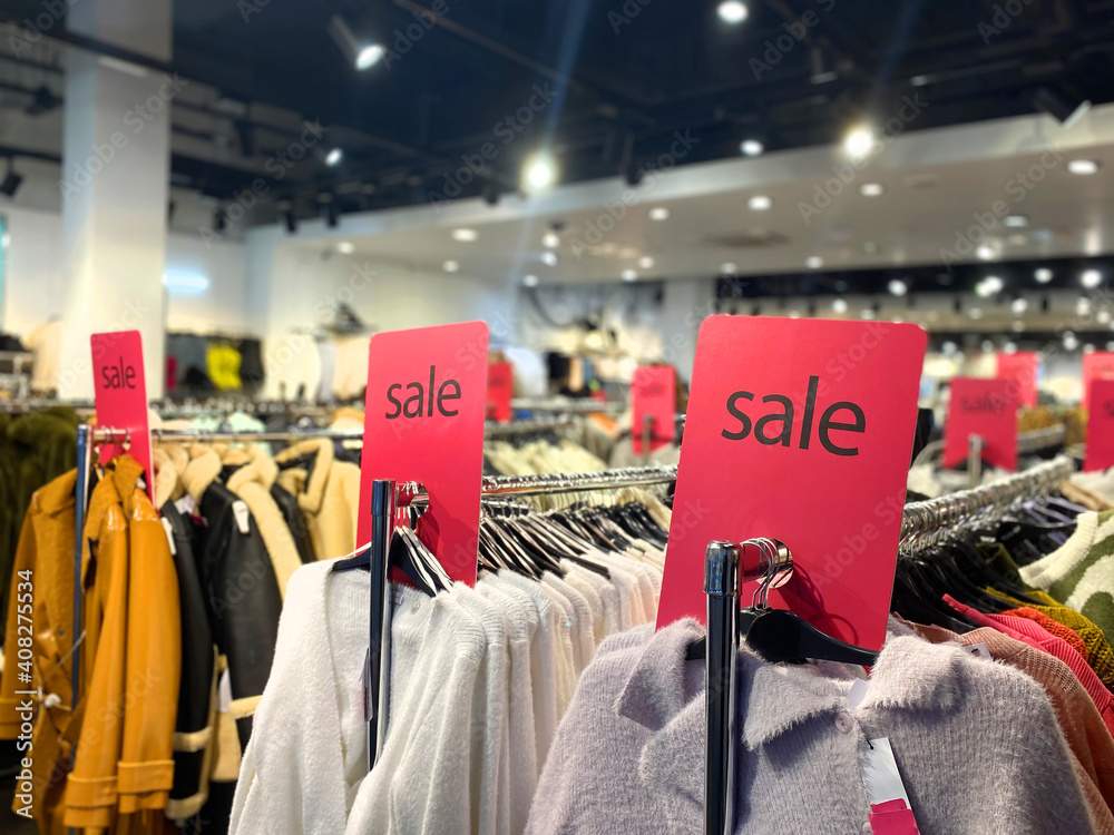 Sale signs above the clothes hangers in the mall. Black Friday in ...