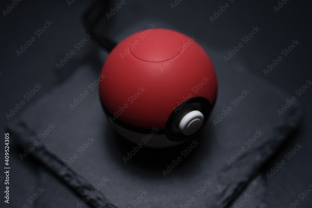 KUALA LUMPUR, MALAYSIA - JUNE 13TH, 2019 : A Poké Ball Plus on a black ...