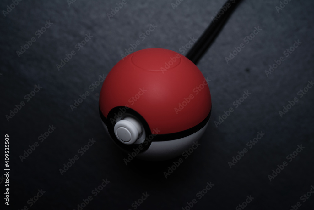 KUALA LUMPUR, MALAYSIA - JUNE 13TH, 2019 : A Poké Ball Plus on a black ...