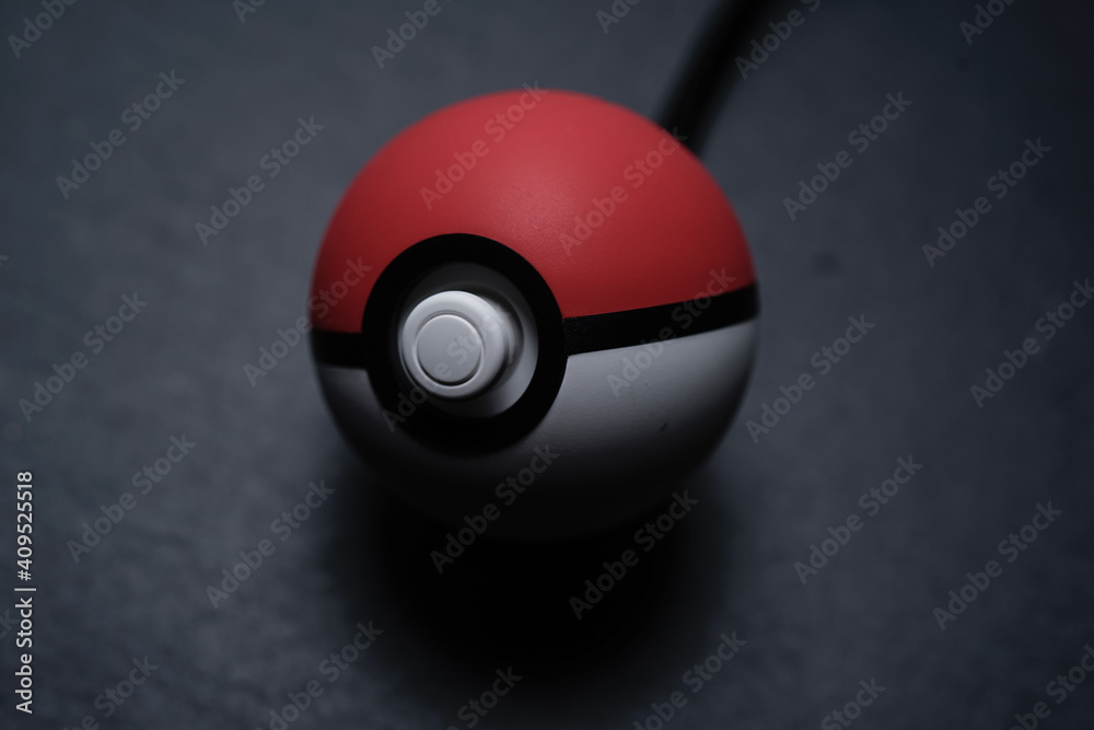 KUALA LUMPUR, MALAYSIA - JUNE 13TH, 2019 : A Poké Ball Plus on a black ...