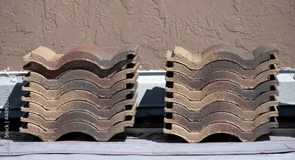 Two stacks of shaded brown curved clay tiles are waiting for ...