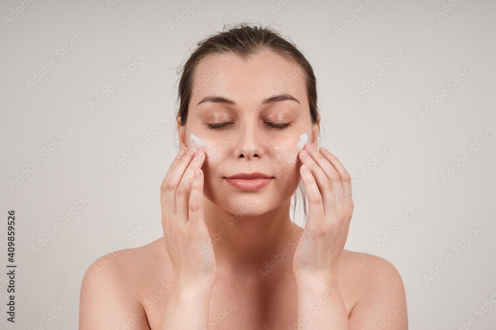 Young Pretty Topless Woman Applying Nourishing Cream To Face Eyes