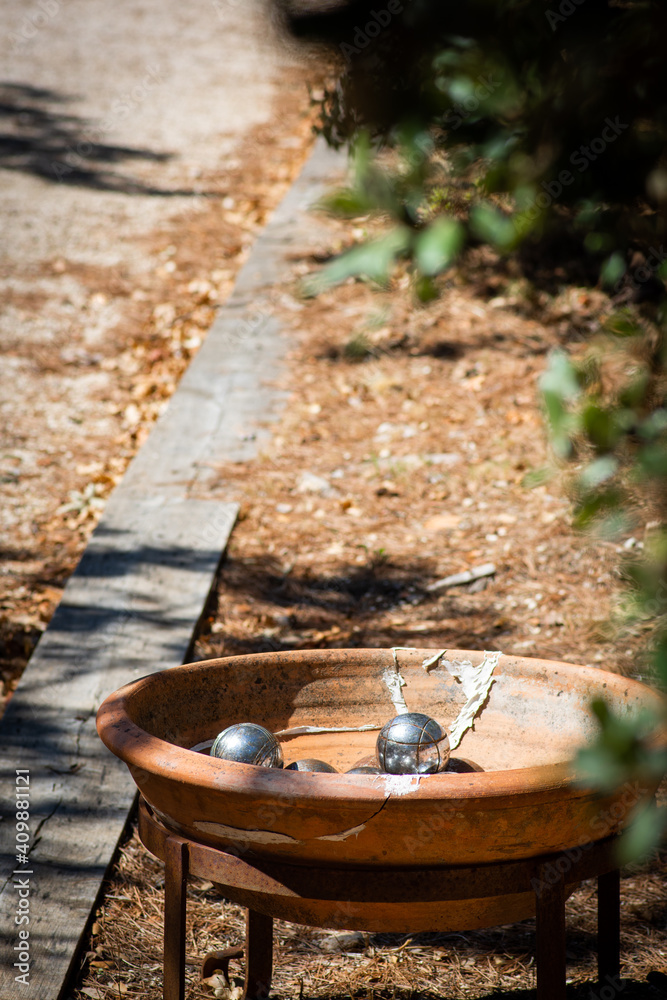 Terracotta dish with jeu de boule balls in the garden. With these steel ...