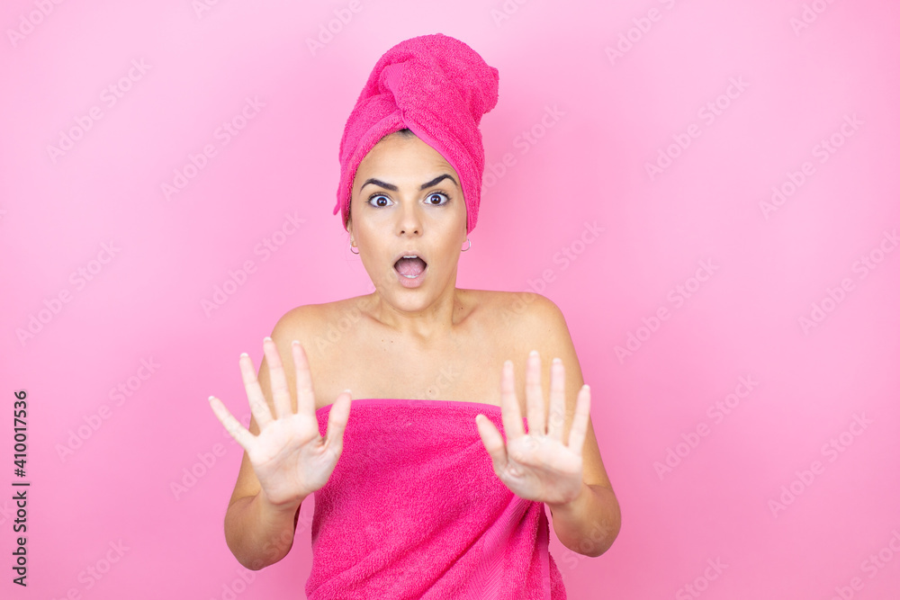 Young beautiful woman wearing shower towel after bath standing over ...