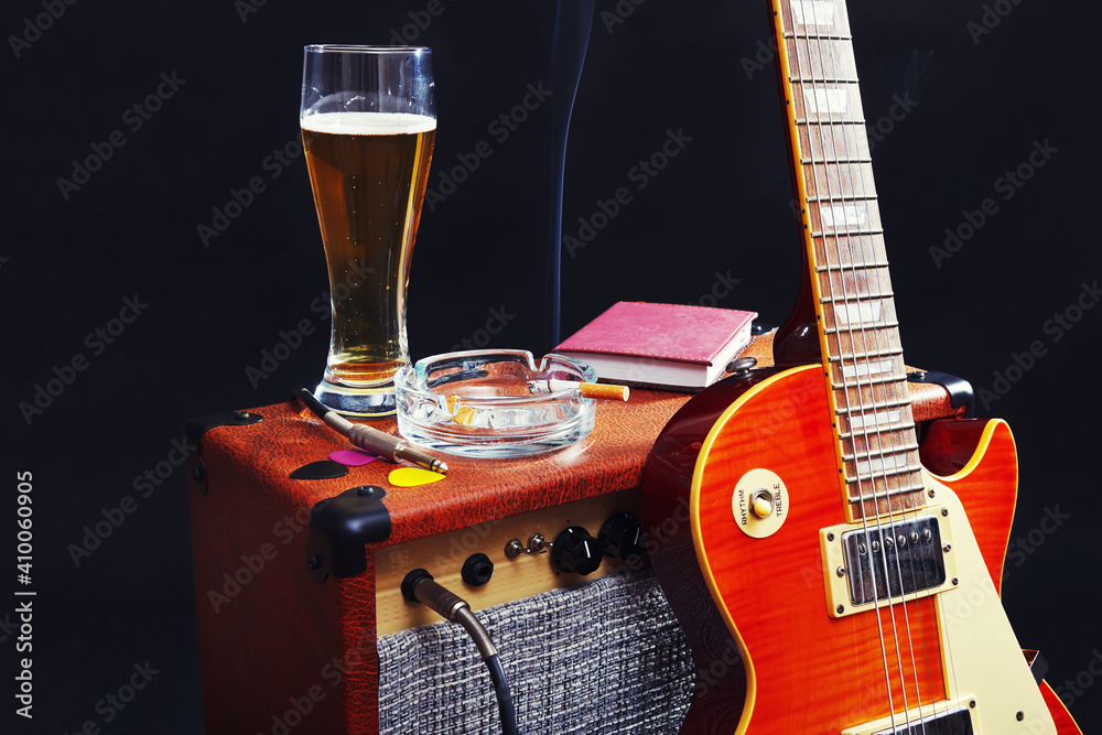 Tube amplifier for electric guitar with guitar, glass of beer and ...