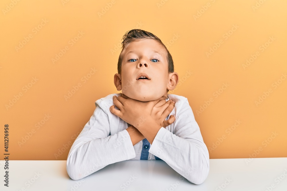 Adorable caucasian kid wearing casual clothes sitting on the table ...
